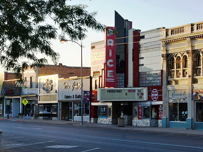 The historic Price Theater stands proudly on Main Street, a crimson reminder of when entertainment was a community affair, not just another streaming service.