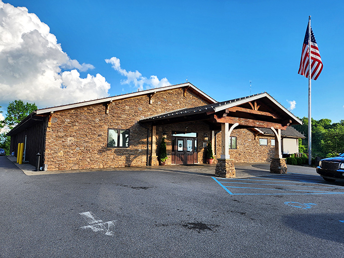 Rustic elegance meets small-town charm at the entrance, where pickup trucks and luxury sedans share parking spaces with equal belonging.