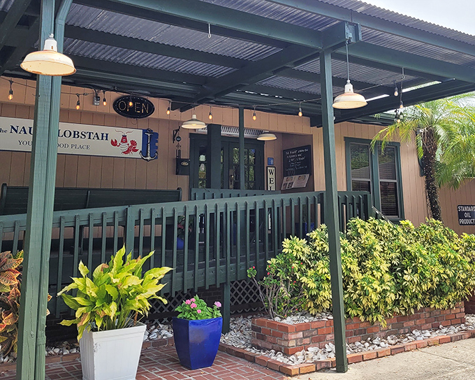 Green railings and potted plants frame this seafood sanctuary where lobster dreams come true.