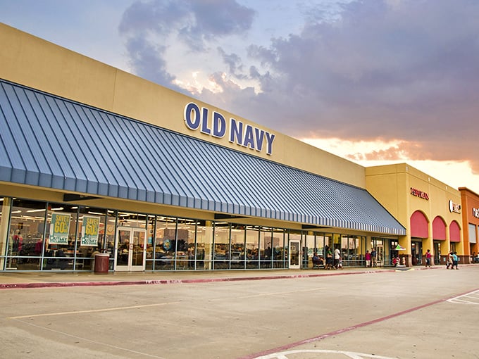 Old Navy's blue awning beckons like a retail lighthouse, guiding bargain hunters safely to shore.