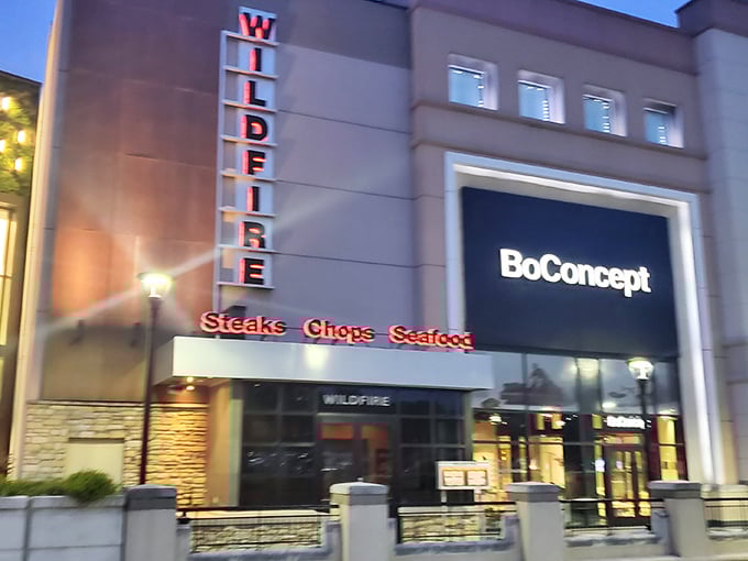 The glowing Wildfire sign beckons hungry travelers like a lighthouse for meat lovers at dusk.