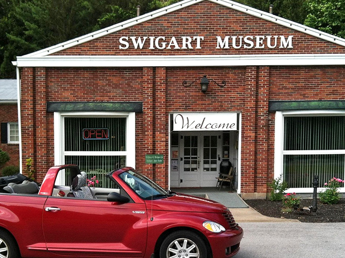 A modern convertible pays homage to its ancestors at the entrance, a fitting reminder of how far automotive design has evolved over the decades.