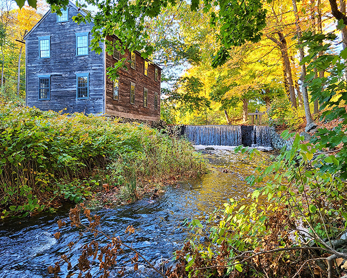 The Arnold House Mill stands as nature's perfect backdrop, where rushing water meets historic architecture in a timeless New England tableau.