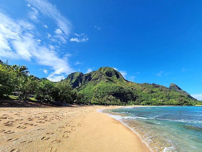 Beach perfection equation: One part golden sand, two parts turquoise water, three parts dramatic mountains. No Instagram filter required.