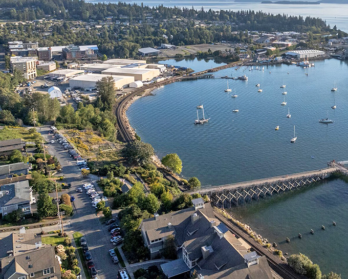 Sailboats dot Bellingham Bay like confetti on blue velvet, while the waterfront seamlessly blends urban development with natural beauty.