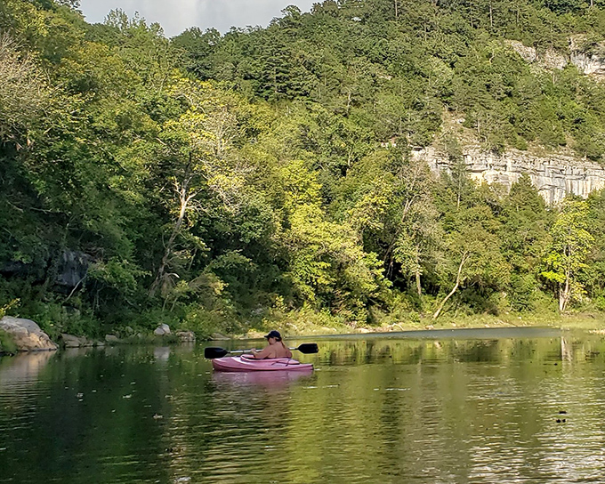 Gliding across mirror-calm water with limestone bluffs watching over you—this is Arkansas showing off its geological resume.