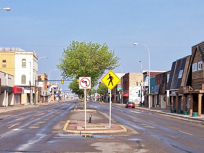 The intersection of yesterday and today, where pedestrian crossing signs stand guard over streets wide enough to turn a horse and buggy.