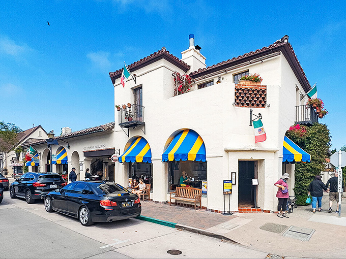 Mediterranean meets whimsy with those blue-and-yellow awnings. This isn't just architecture; it's a mood you can walk into.
