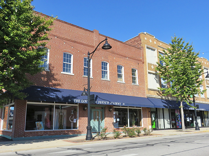 Sunlight plays across the brick facades of Main Street shops, where blue awnings offer shade and the promise of treasures that can't be found with a one-click purchase.