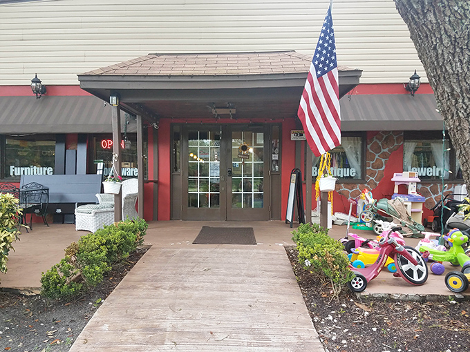 The American flag waves a patriotic welcome at this red-trimmed entrance, where children's toys hint at the bargains awaiting inside.
