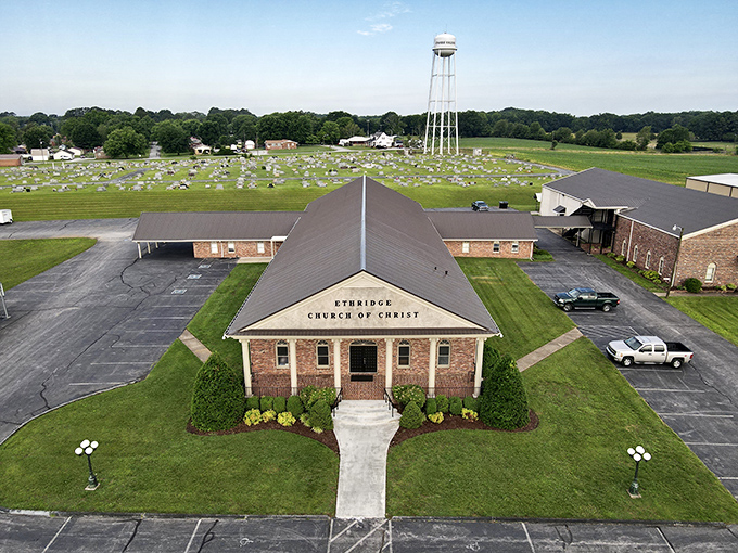 The Ethridge Church of Christ anchors the community with its simple brick architecture and towering water tank backdrop. Faith and function in perfect harmony.