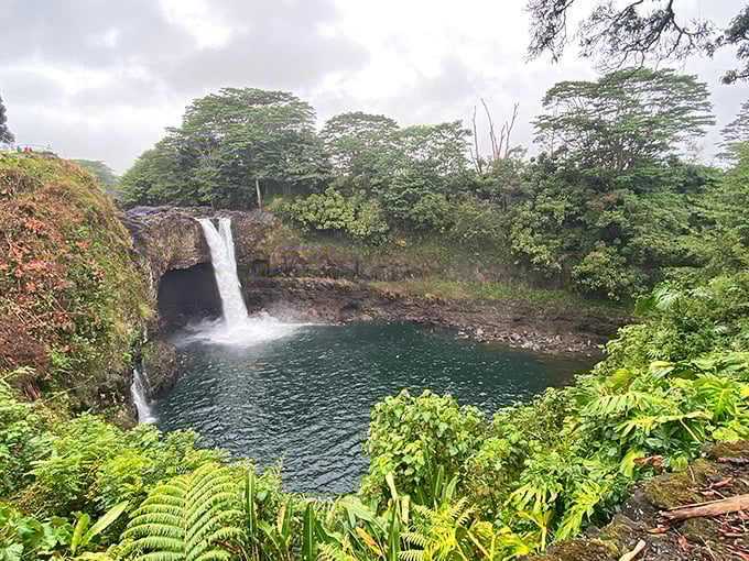 That cave behind the waterfall once sheltered Hawaiian legends, and honestly, who could blame them for choosing this view?