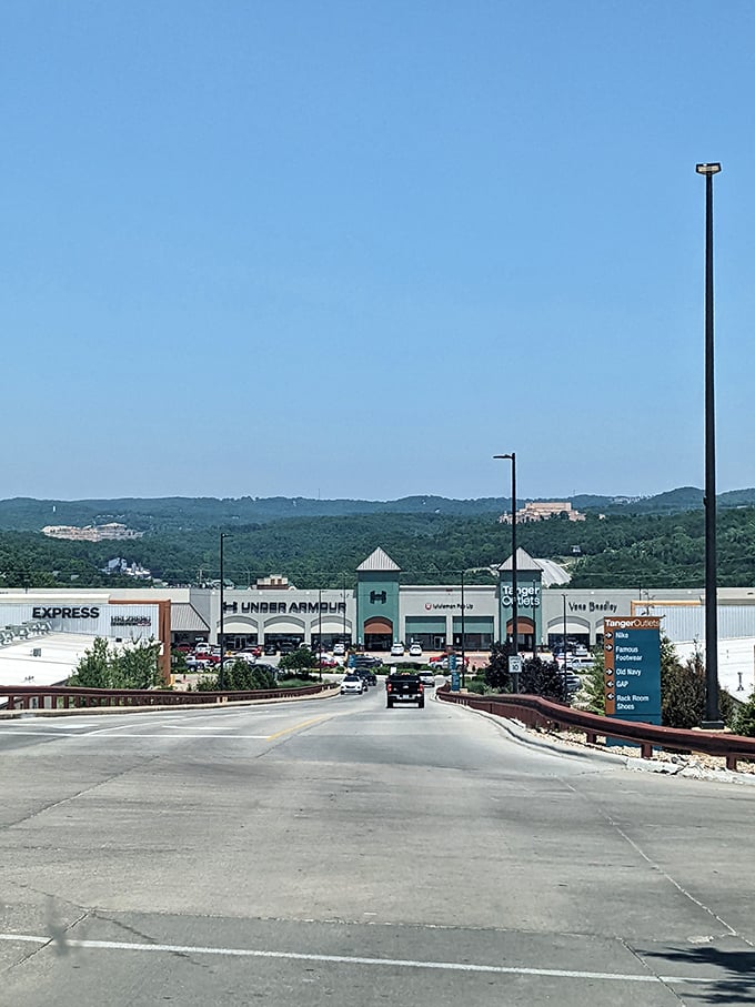 Approaching shopping paradise: Tanger Outlets nestled against the rolling Ozark hills, where wallets come to dance and credit cards come to play.