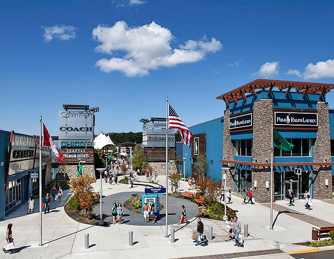 The central plaza with its flags and stone facades serves as both landmark and meeting point for separated shopping parties.
