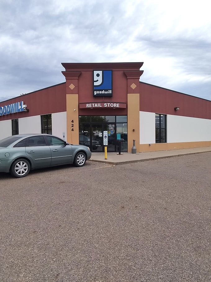Bathed in golden hour light, the Goodwill storefront stands ready for another day of treasure hunting. Even the building seems to smile with that distinctive logo.