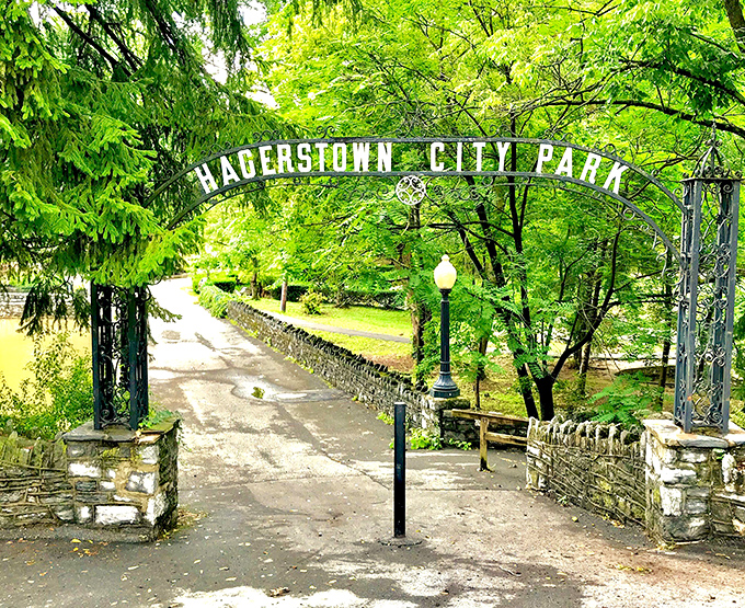The entrance to Hagerstown City Park feels like stepping through a portal to simpler times, where stone archways and verdant canopies welcome visitors to urban tranquility.
