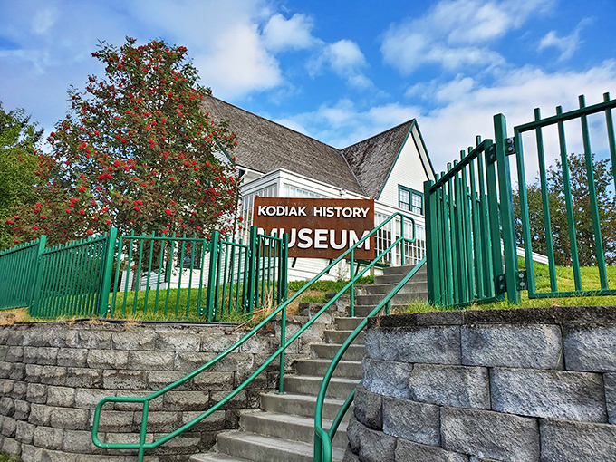 The Kodiak History Museum isn't just a building&mdash;it's a time machine disguised as a charming white house with green railings and vibrant flowering trees.