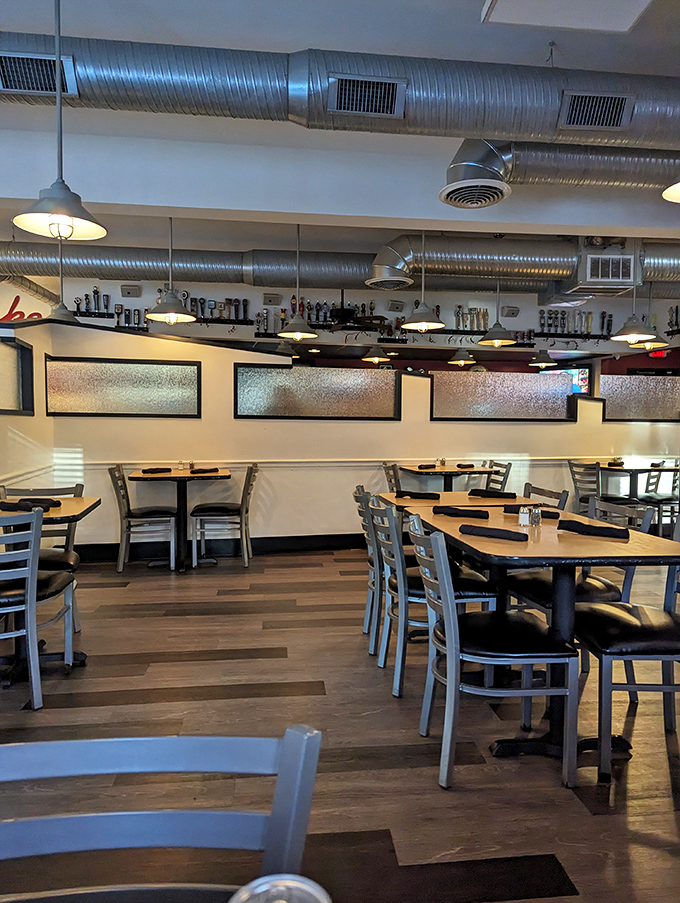 Industrial chic meets comfort in this dining room where exposed ductwork watches over wooden tables that have witnessed countless "first bite" moments of burger bliss.