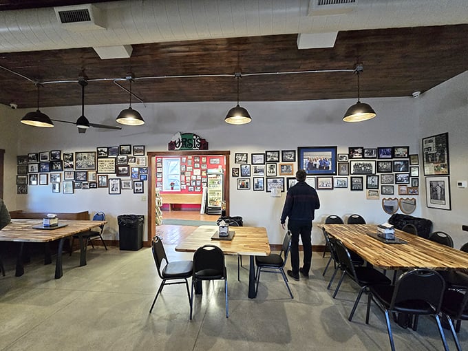 History serves as wallpaper here. The dining area's photo-covered walls tell stories of community while simple wooden tables invite you to create your own memories.