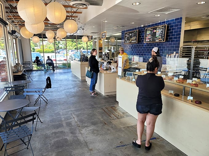 Paper lanterns float above concrete floors while that stunning blue tile wall serves as the backdrop for donut dreams coming true.