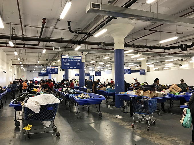 The retail equivalent of the Wild West. Shoppers navigate a sea of blue bins, each potentially hiding the next great find.