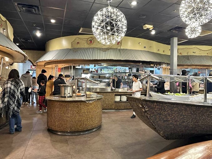 Spherical light fixtures hover like delicate moons above the buffet stations, where diners navigate a sea of culinary options with the focus of seasoned explorers.