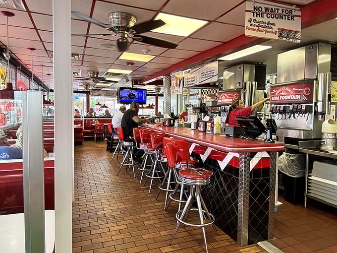Inside, the gleaming counter and cherry-red stools aren't retro by design—they're authentic survivors from an era when "fast food" meant service with a smile.