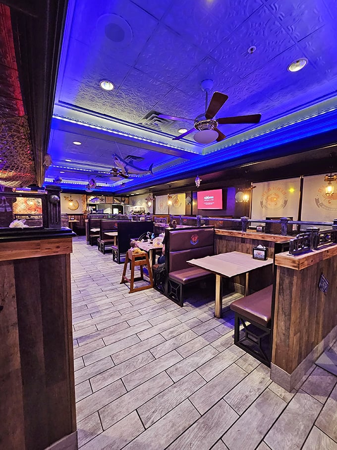 Step inside to discover a dining room bathed in oceanic blue lighting, where wooden booths await your seafood adventure and conversations flow as freely as the butter sauce.