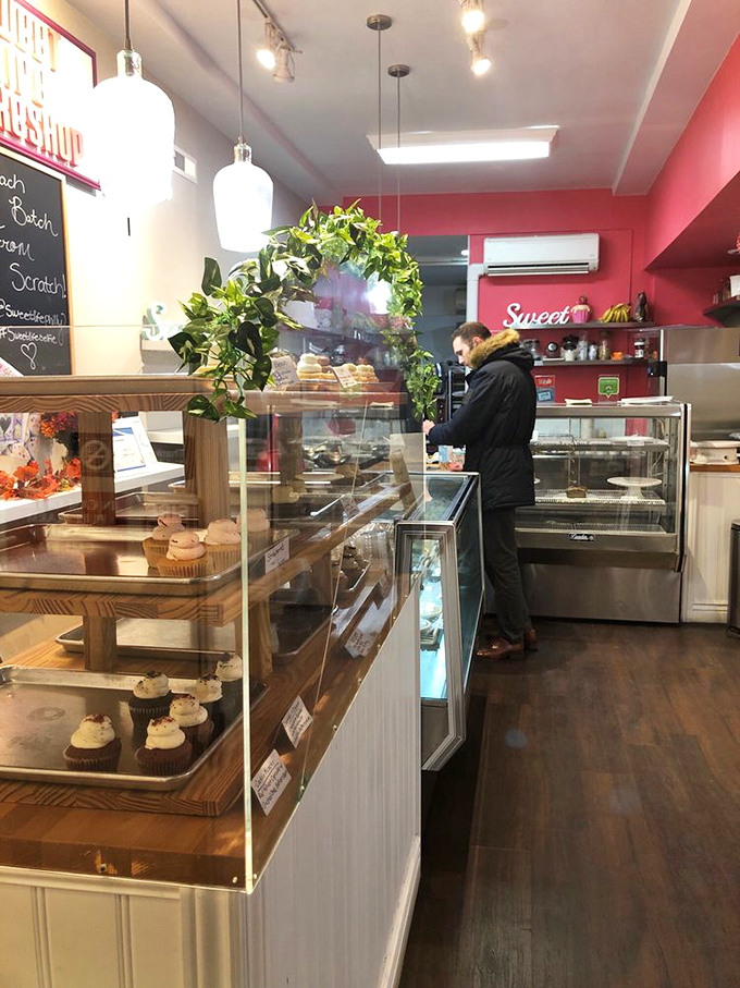 Inside, warm pendant lighting and that signature pink wall create the perfect backdrop for life-changing dessert decisions. The display cases are basically sugar-filled jewelry boxes.