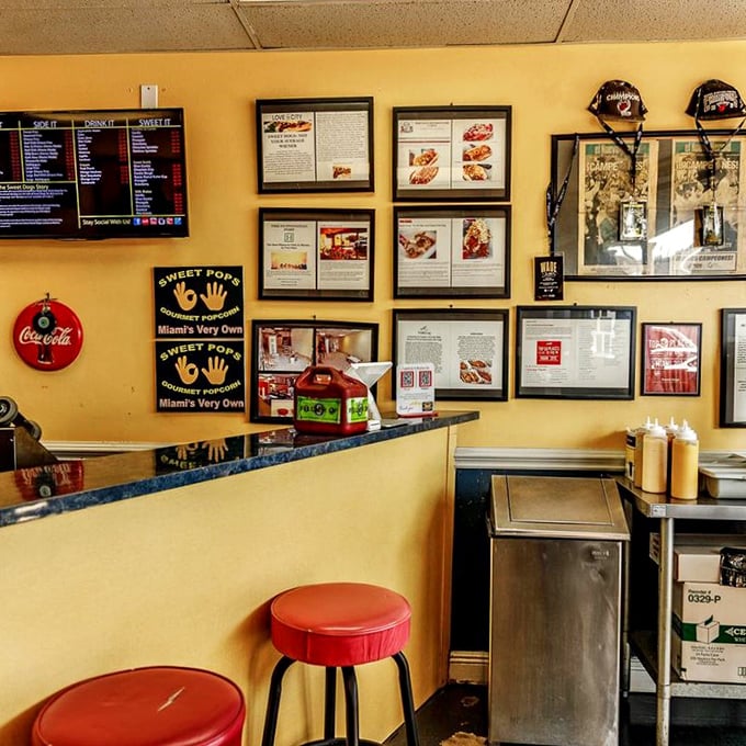 Yellow walls adorned with framed accolades tell the story of Sweet Dogs' rise to fame, while red stools invite you to be part of the next chapter.