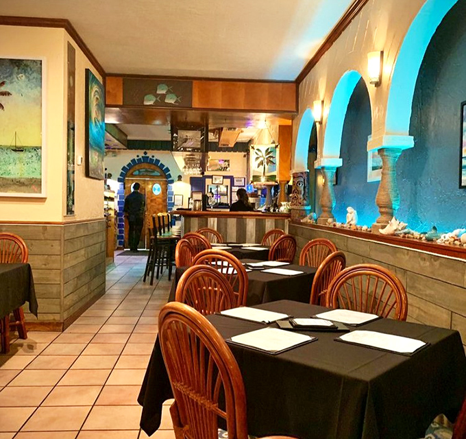 The Mediterranean-inspired interior with those signature turquoise arches transforms a simple meal into a coastal escape. Like stepping into a postcard from a Greek island.