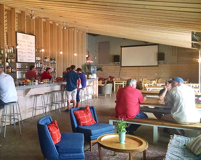 Light wood, blue accents, and communal tables—this interior feels like the living room of your coolest friend who happens to make incredible cocktails.