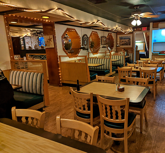 Nautical charm meets cozy comfort inside Kelly's, where octagonal mirrors, string lights, and blue-striped booths create the perfect backdrop for seafood indulgence.