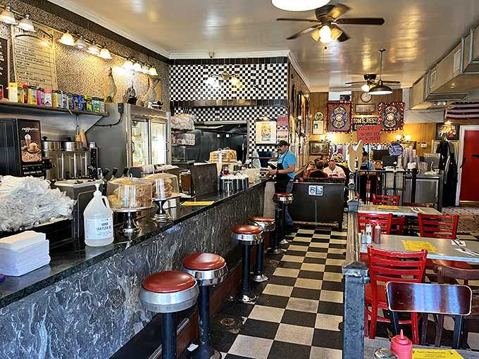 The checkered floor and chrome counter stools aren't retro by design—they're authentic by survival, outlasting countless food trends and fads.