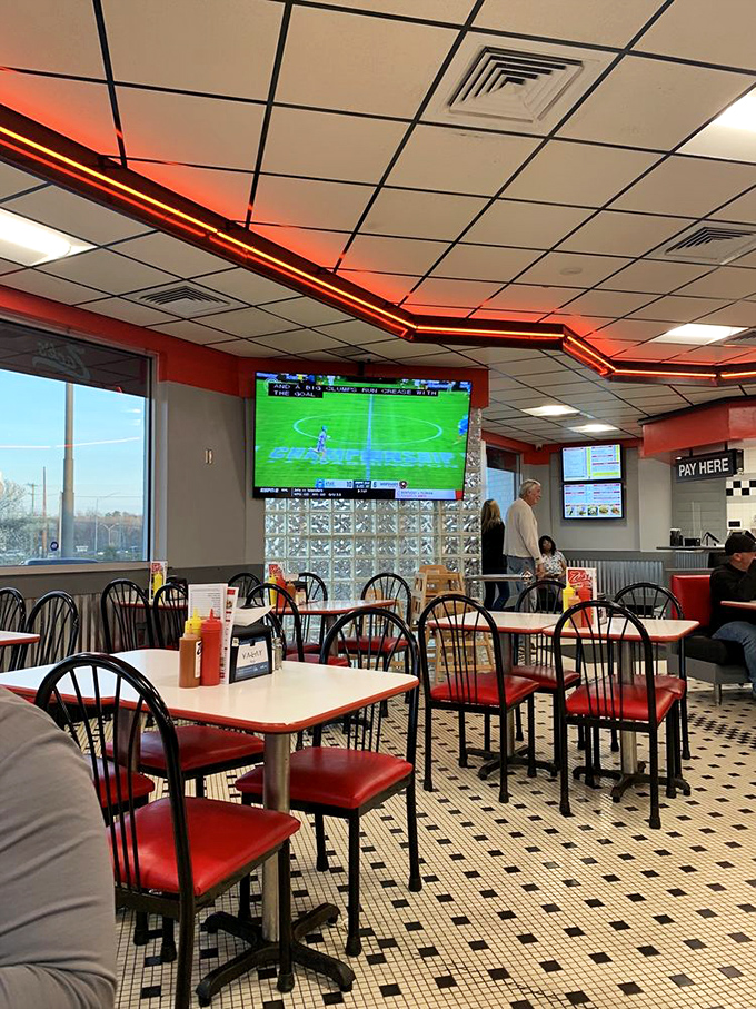 Inside, the classic diner aesthetic with red accents and checkerboard floors sets the stage for hot dog perfection.
