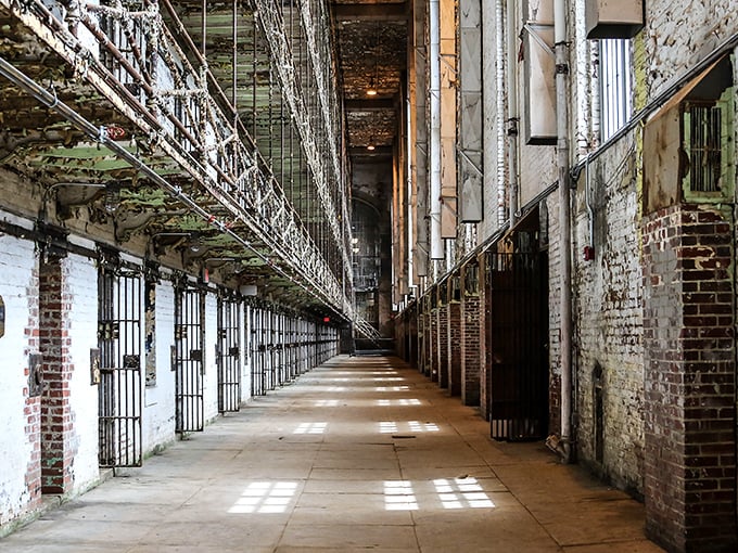 Six tiers of steel and despair stretch toward the ceiling in the East Cell Block. Sunlight creates haunting patterns on a floor that's witnessed countless shuffling footsteps.