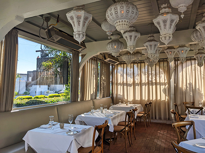 Delicate white lanterns cast a dreamy glow across the veranda, creating an atmosphere that's equal parts elegant and California casual.