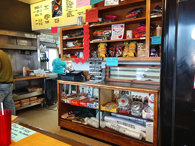 Behind this nostalgic counter, burger magic happens. The shelves stocked with snacks and memorabilia tell stories of decades serving Urbana.