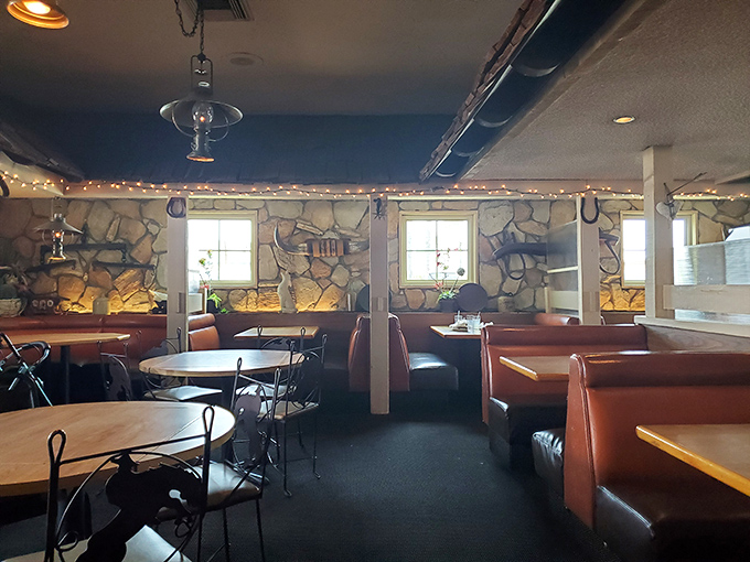 Step inside and you're transported to a cozy Western haven where stone walls, wooden booths, and twinkling string lights create the perfect backdrop for serious steak business.