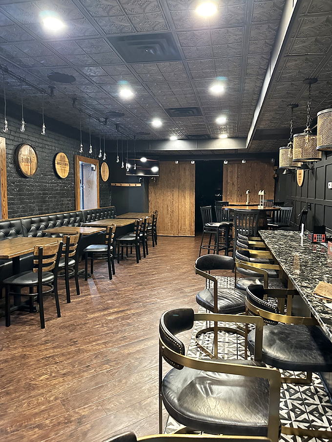 Step inside to discover a cozy sanctuary where barrel tops adorn exposed brick walls, leather booths invite lingering conversations, and the promise of comfort food awaits.