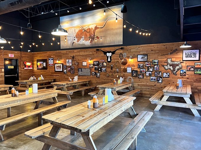Wooden picnic tables, Texas memorabilia, and string lights create the perfect backdrop for the serious business of brisket appreciation.