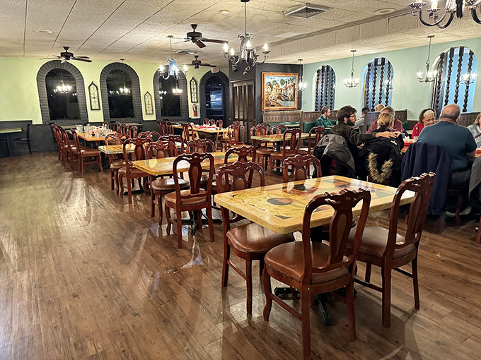 Mint-green walls, wooden chairs, and arched windows create an atmosphere that's part hacienda, part Akron charm. The chandeliers cast that perfect "everyone looks good" lighting.