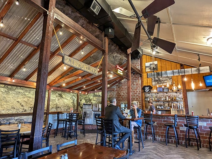 Inside, the restaurant's genius reveals itself&mdash;actual cliff face forms the back wall, while wooden beams and corrugated metal create a cozy, rustic atmosphere.