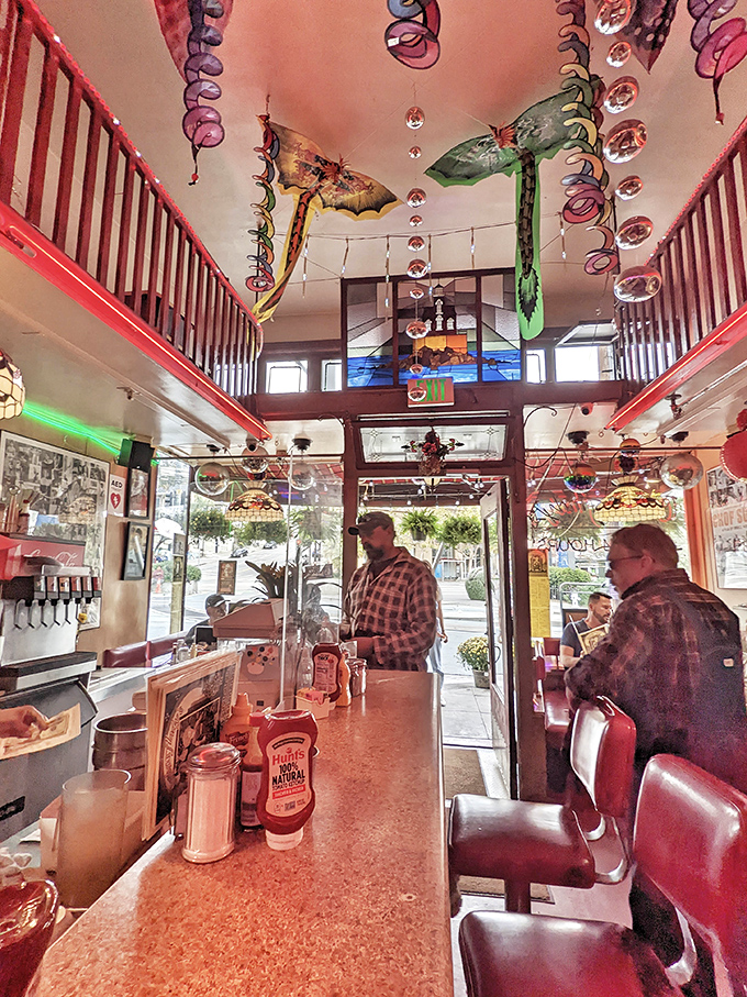 Look at those decorations dancing overhead – it's like Mardi Gras decided to permanently move into a diner.