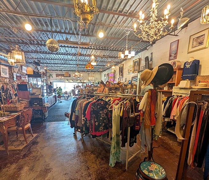 Vintage chandeliers illuminate racks of colorful clothing treasures beneath industrial ceilings&mdash;proof that the best interior decorating combines champagne taste with beer budget sensibilities.