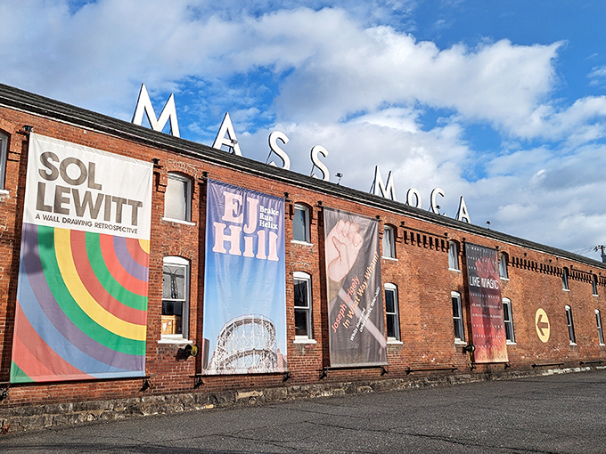 MASS MoCA's industrial-chic exterior showcases vibrant art banners against brick and sky—a factory once making components now manufactures wonder and inspiration.