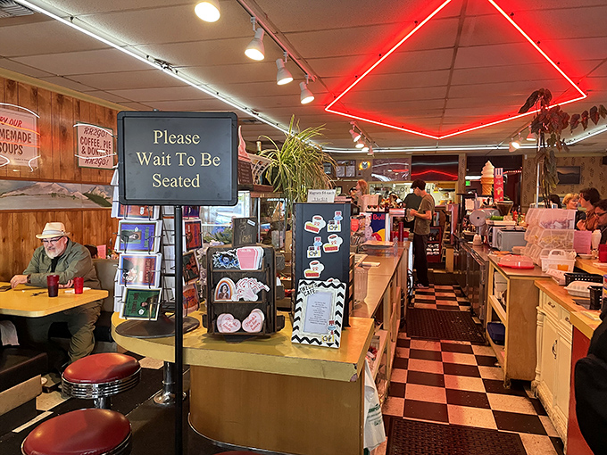 Step inside and the classic diner charm hits you immediately &ndash; red neon, checkered floors, and the promise of being seated soon.