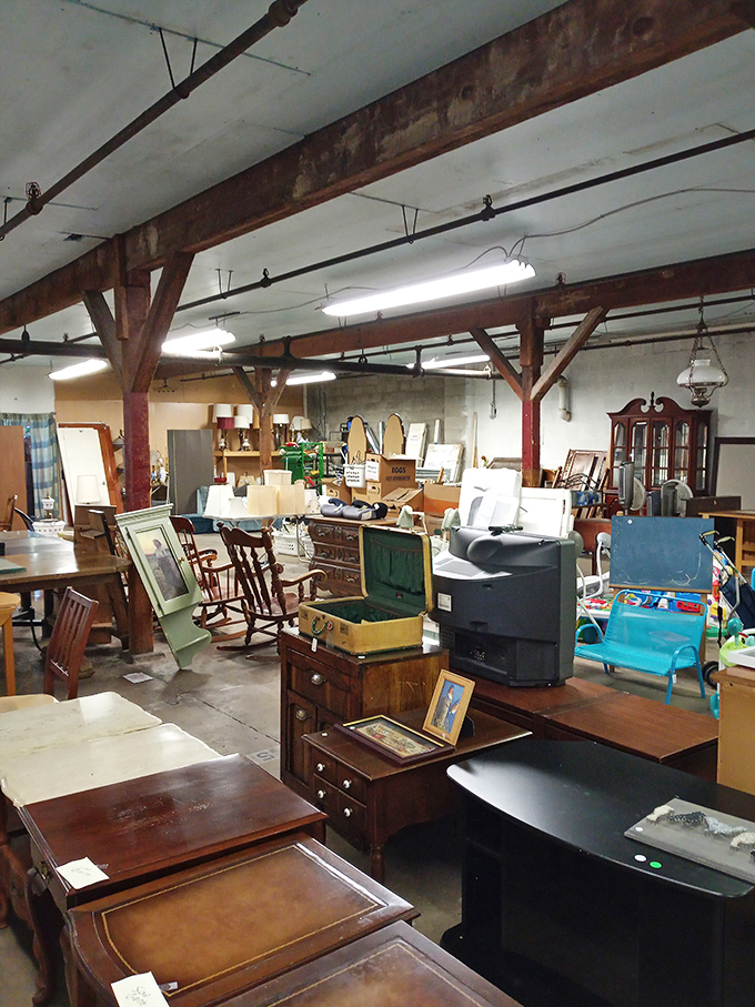 Wooden beams frame this furniture wonderland where mid-century meets colonial. That perfect coffee table is hiding somewhere between decades.