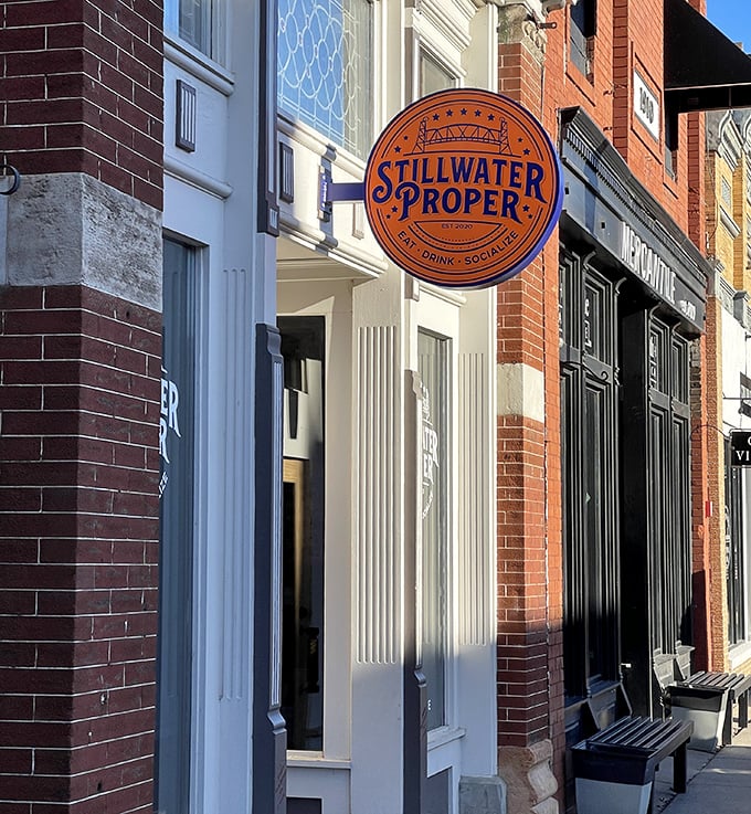 Stillwater Proper's orange sign promises what every traveler hopes for: a place where locals actually want you to join them.