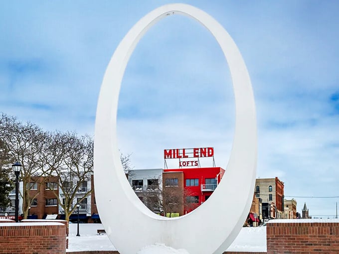 The Mill End Lofts, framed by this striking oval sculpture, prove that art and architecture can coexist without emptying your 401(k).